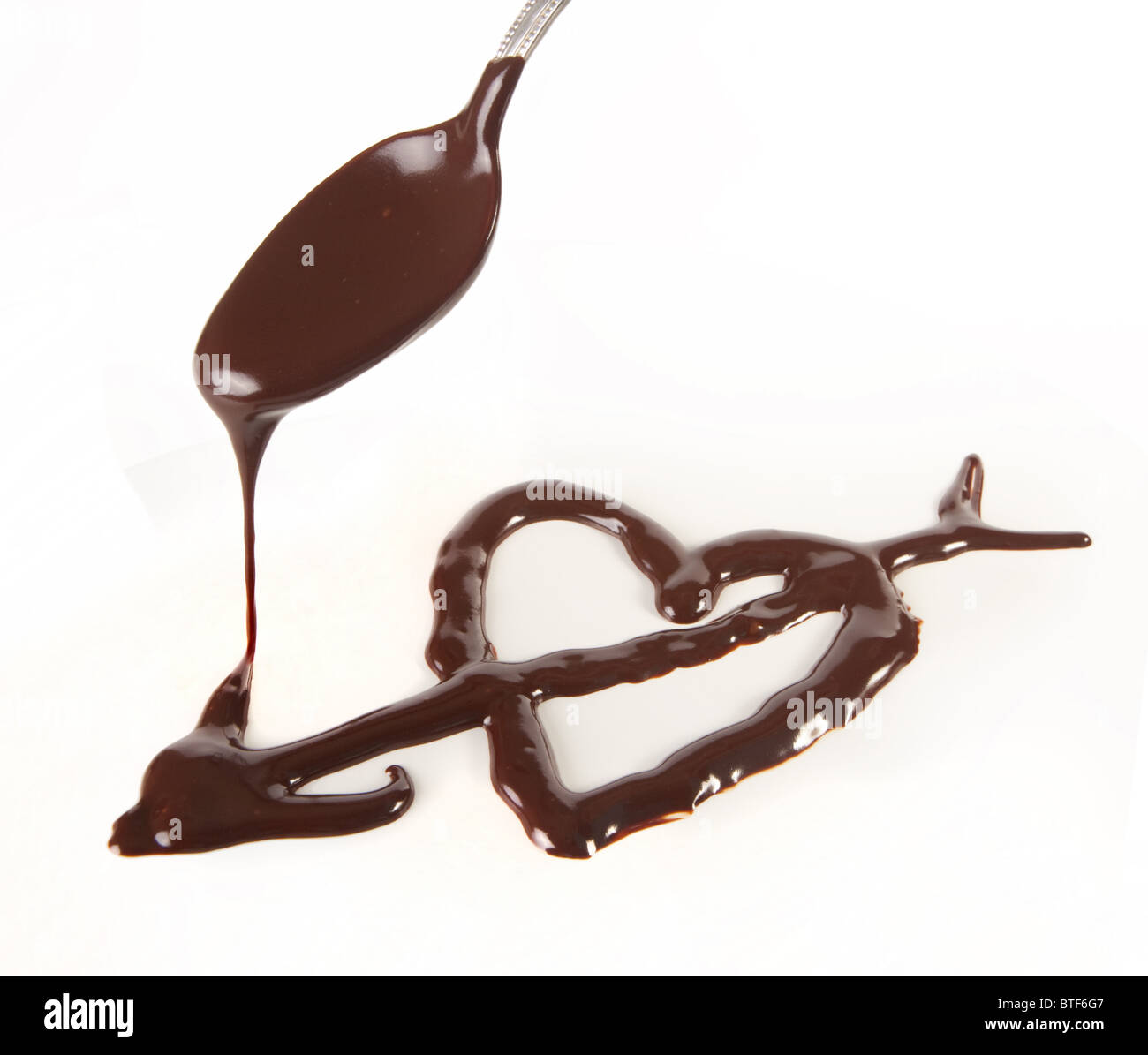Drawing a chocolate heart for Valentine's day with a spoon Stock Photo ...