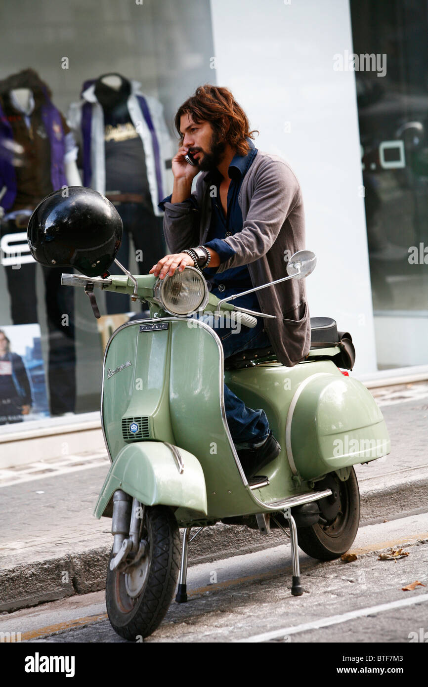 Young man sitting on a vespa at Rhodes New Town, Rhodes, Greece Stock ...