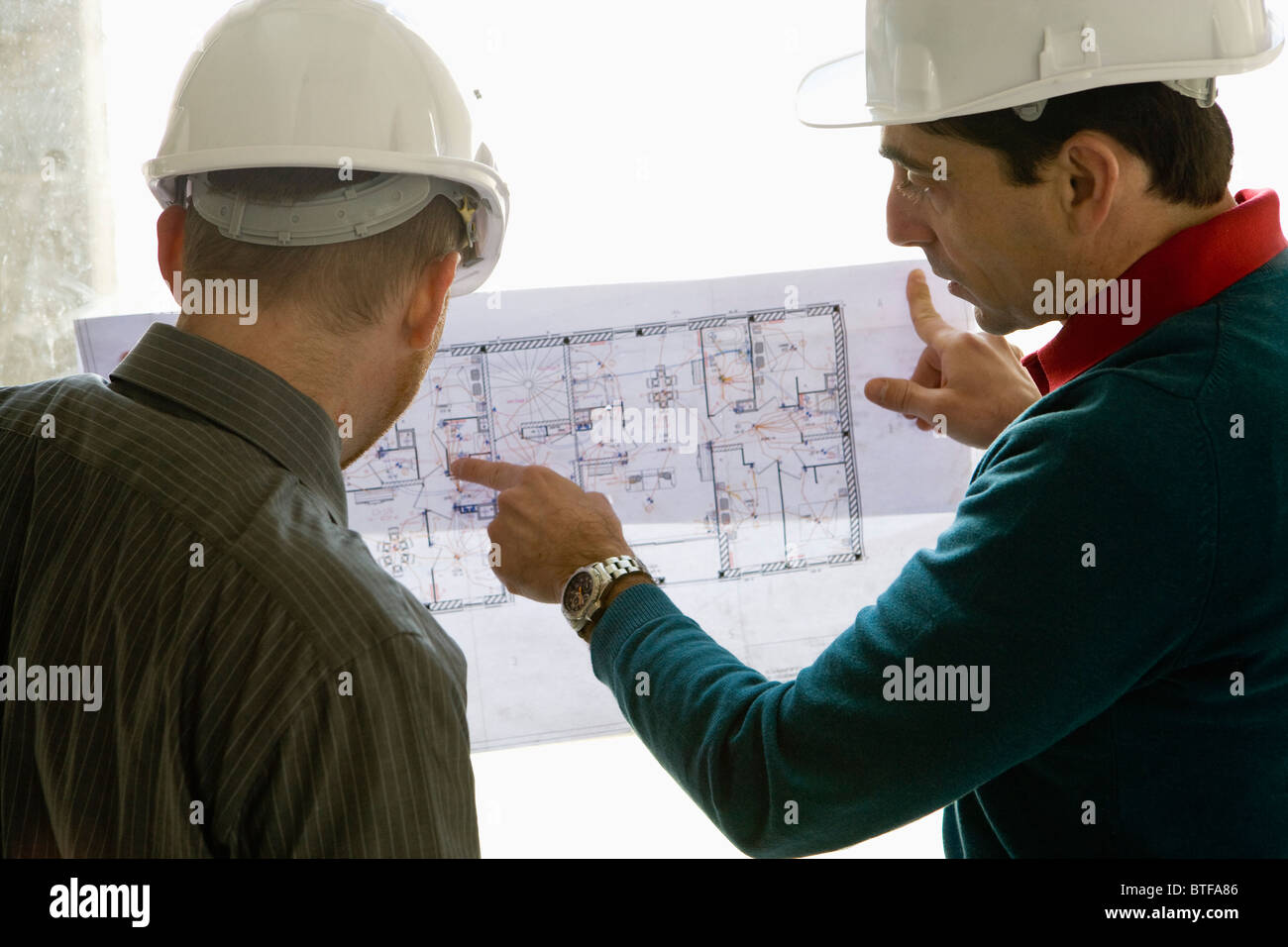 Building contractor explaining blueprint Stock Photo - Alamy