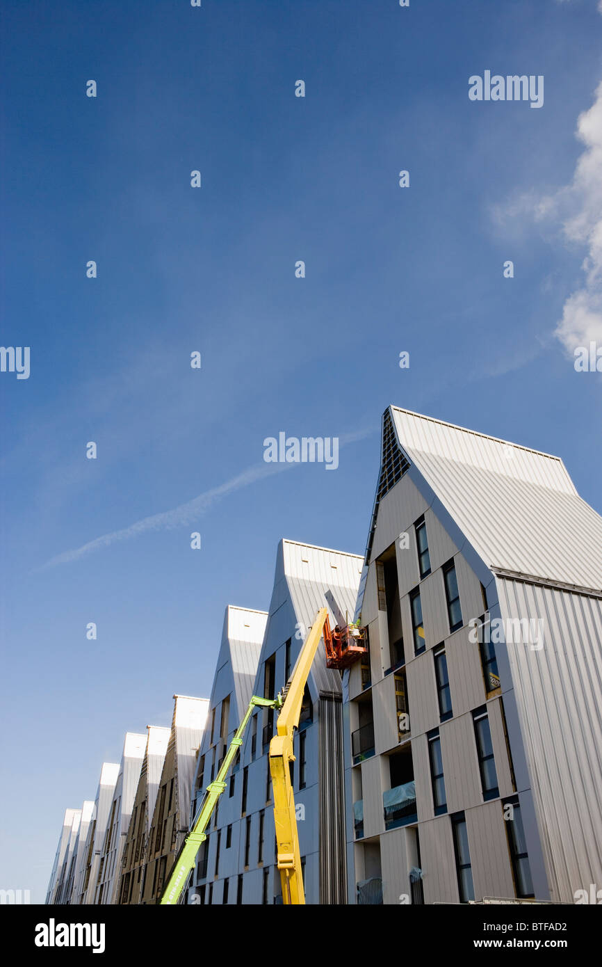 Construction workers in cherry picker bucket working on building ...
