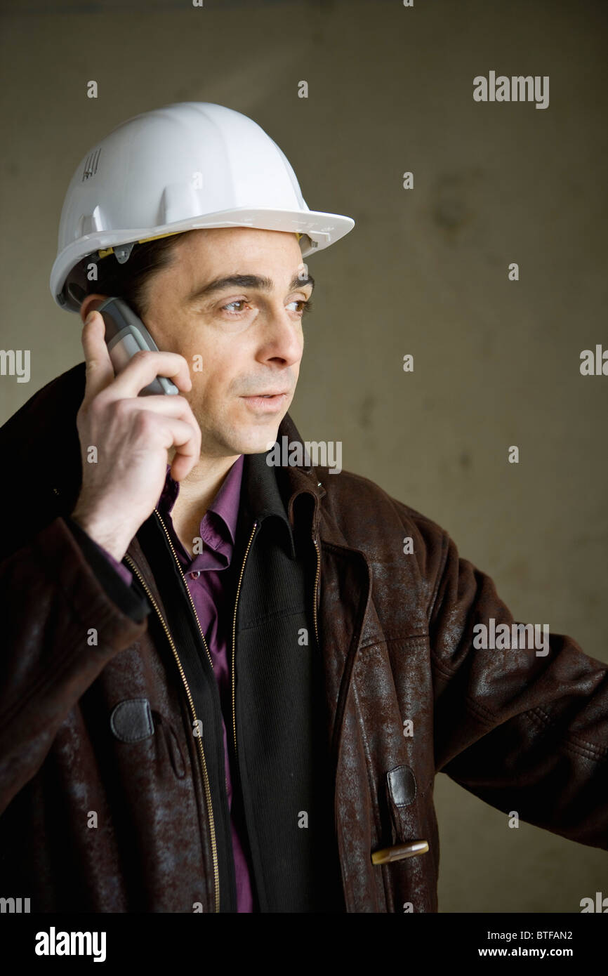 Building contractor using cell phone Stock Photo - Alamy