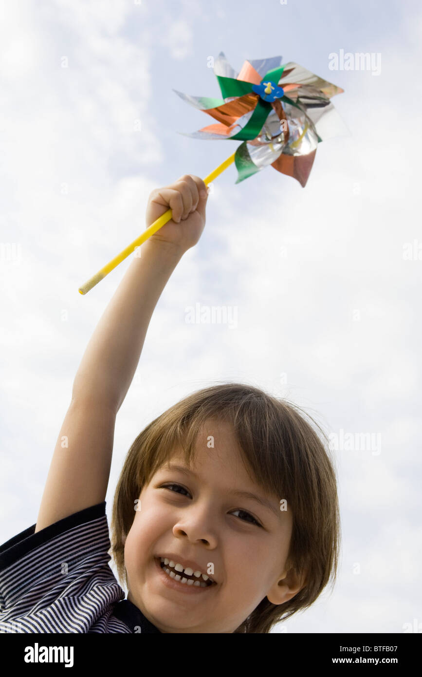 Boy holding up pinwheel outdoors, portrait Stock Photo - Alamy