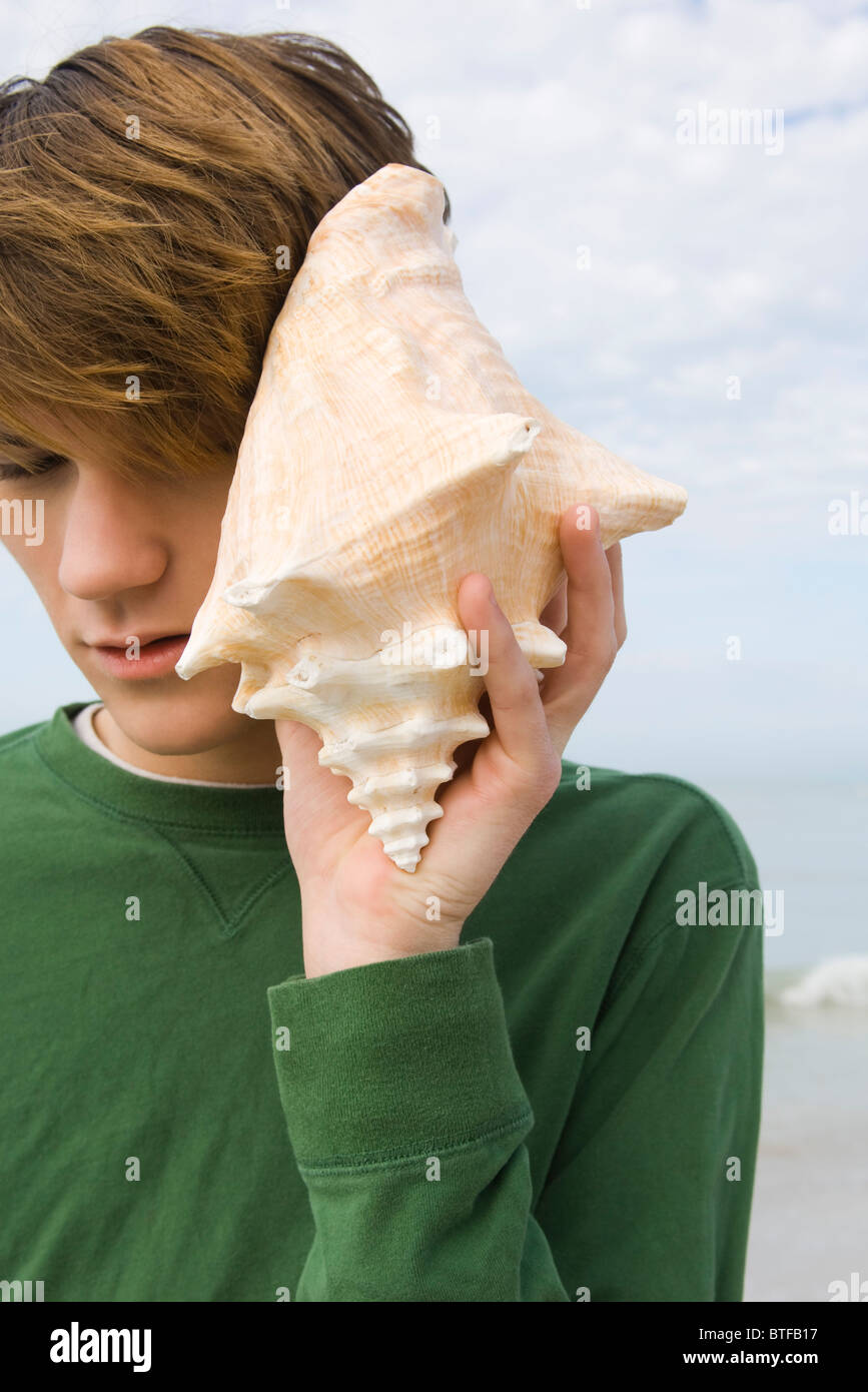 Man listening to seashell hi-res stock photography and images - Alamy