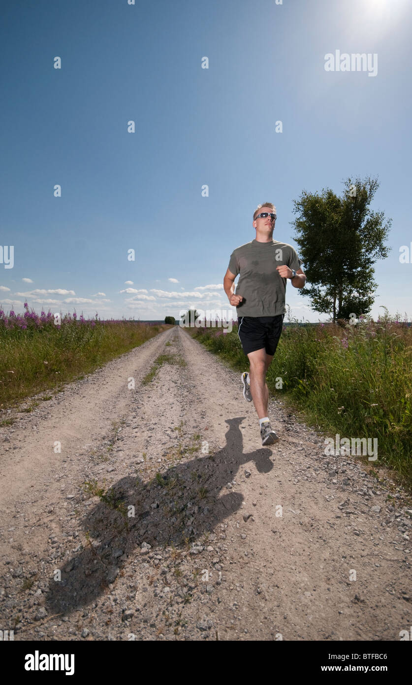 Athletic male running on field road on hot summer day Stock Photo - Alamy