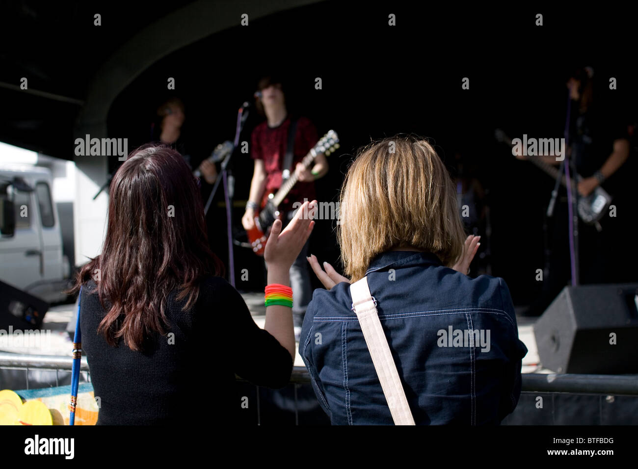 A couple of young fans watch rock band in the park Stock Photo - Alamy