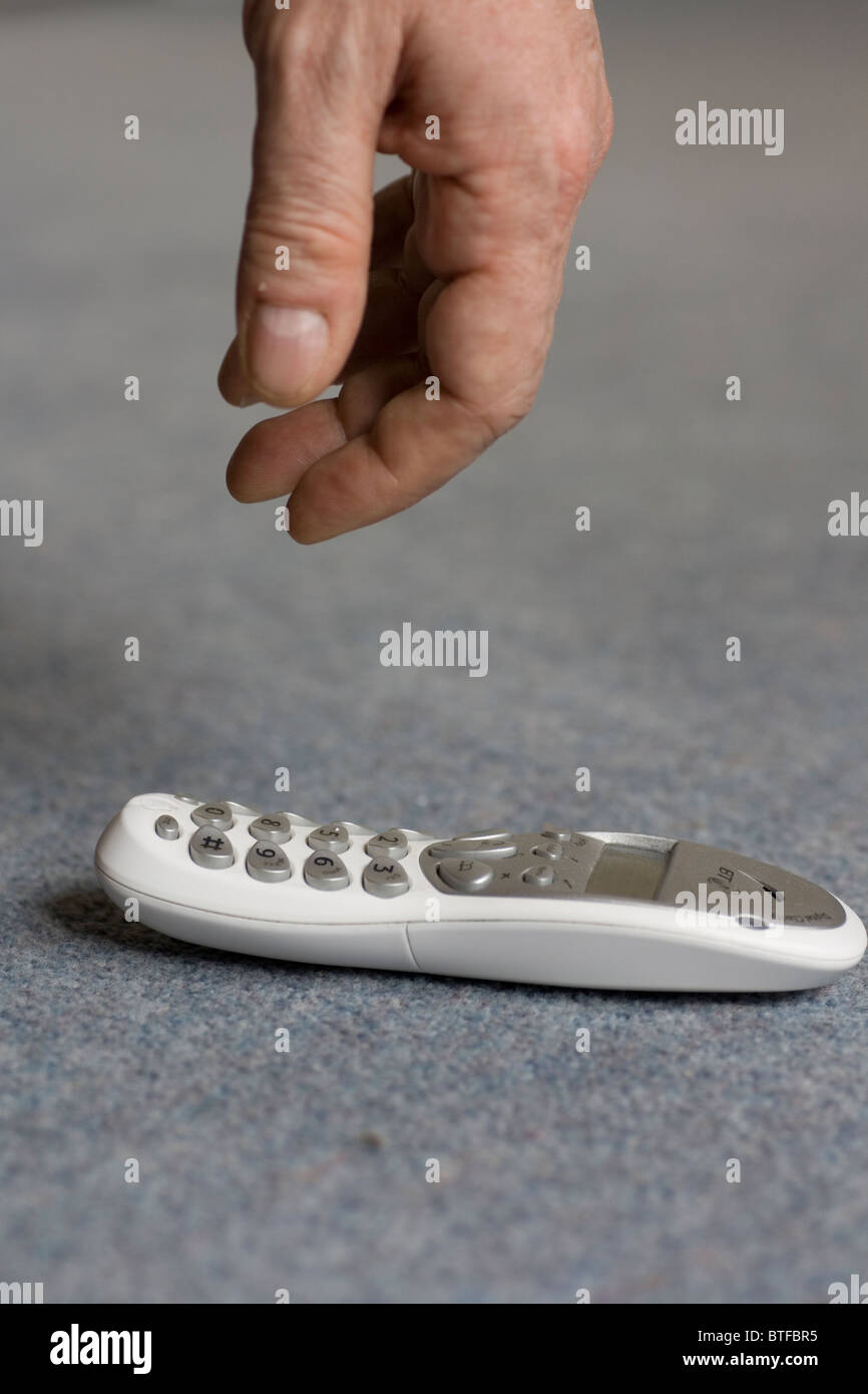 A hand hangs over a telephone on the floor Stock Photo - Alamy