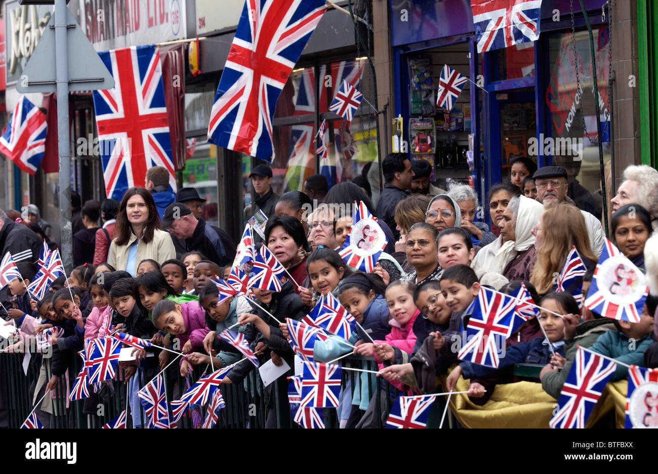 Crowds with Union Jack flags in Green Street in the East End of London ...