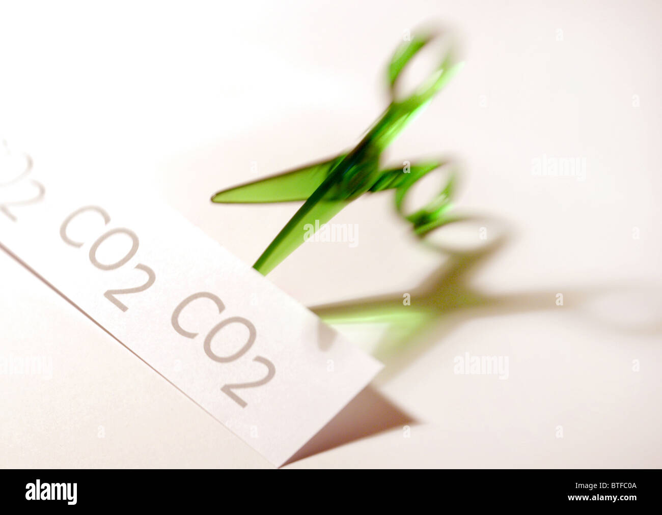 Carbon (CO2) reduction / cuts concept featuring green scissors cutting ...