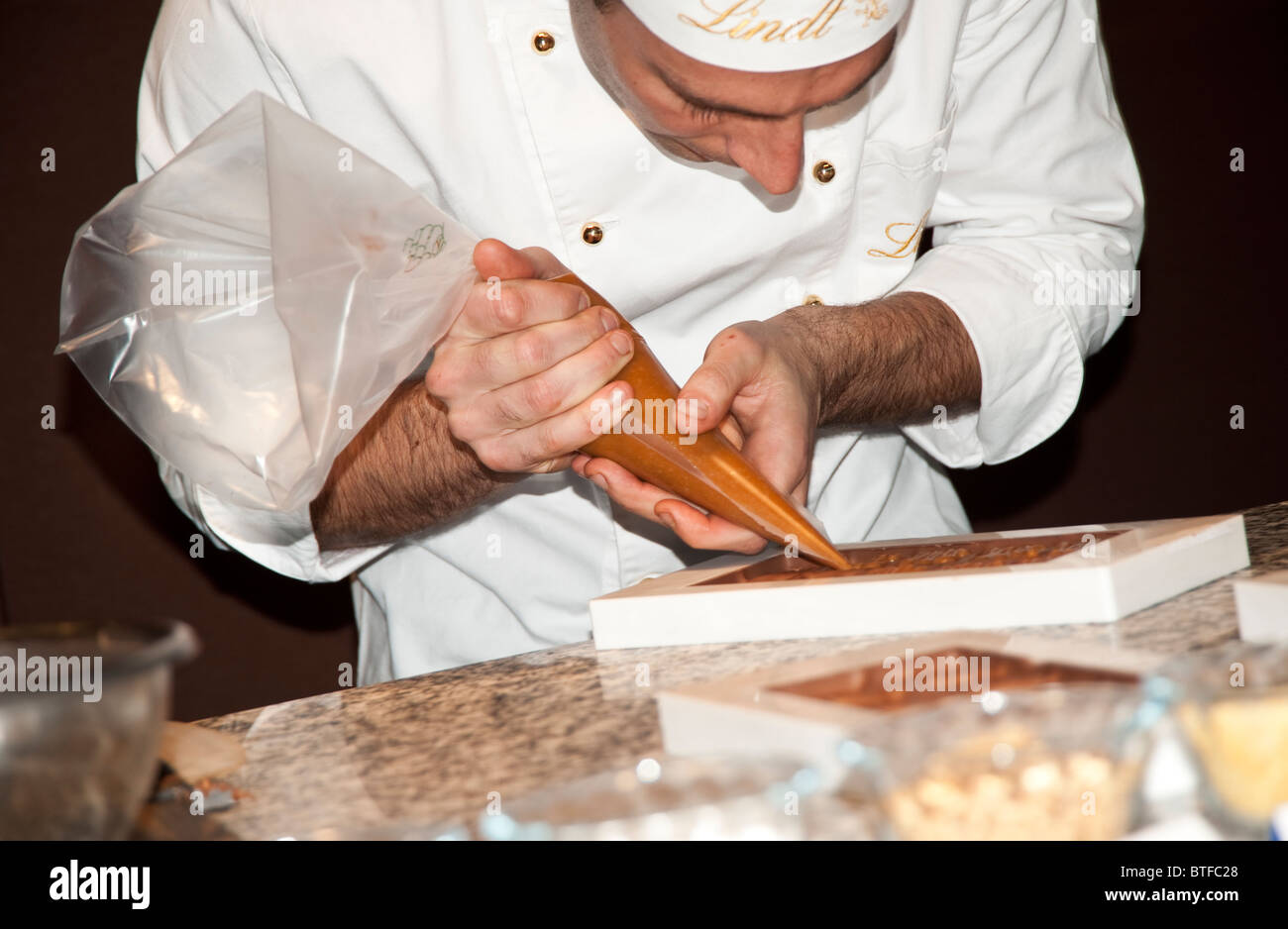 A chef pours chocolate into trays to make Lindt chocolates, " Salon du ...