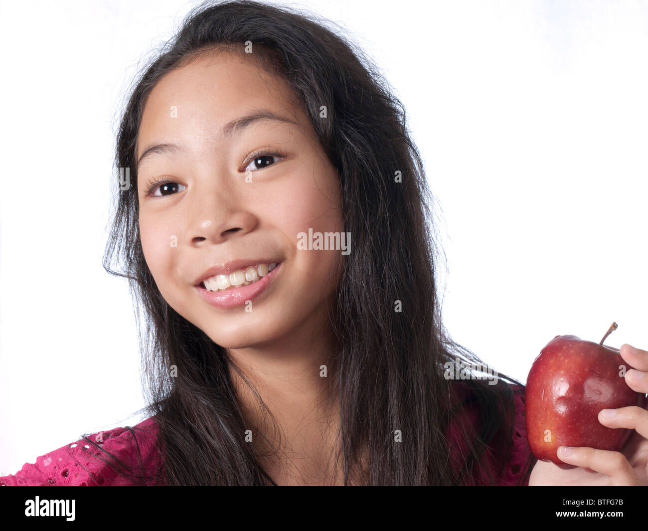 A teenage girl enjoys eating an apple Stock Photo - Alamy
