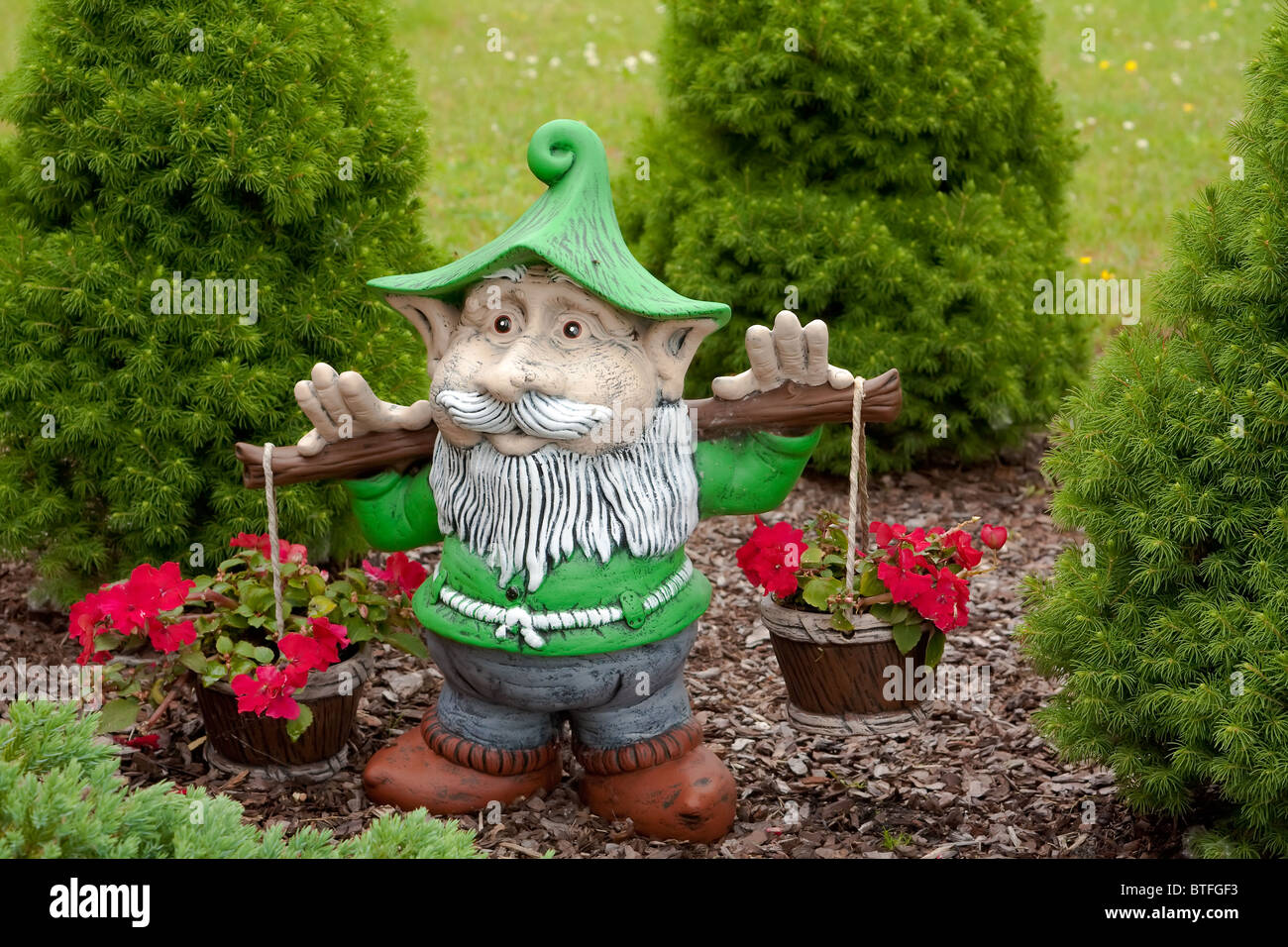 Elf holding red flowers in the garden Stock Photo - Alamy