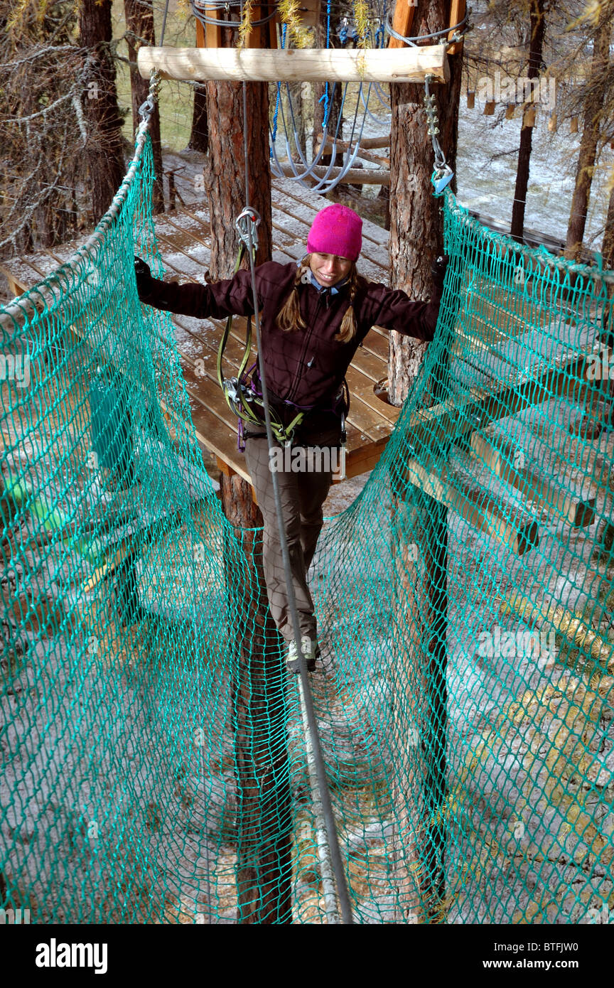 Woman tightrope walking at Hochseilgarten rope adventure park in ...
