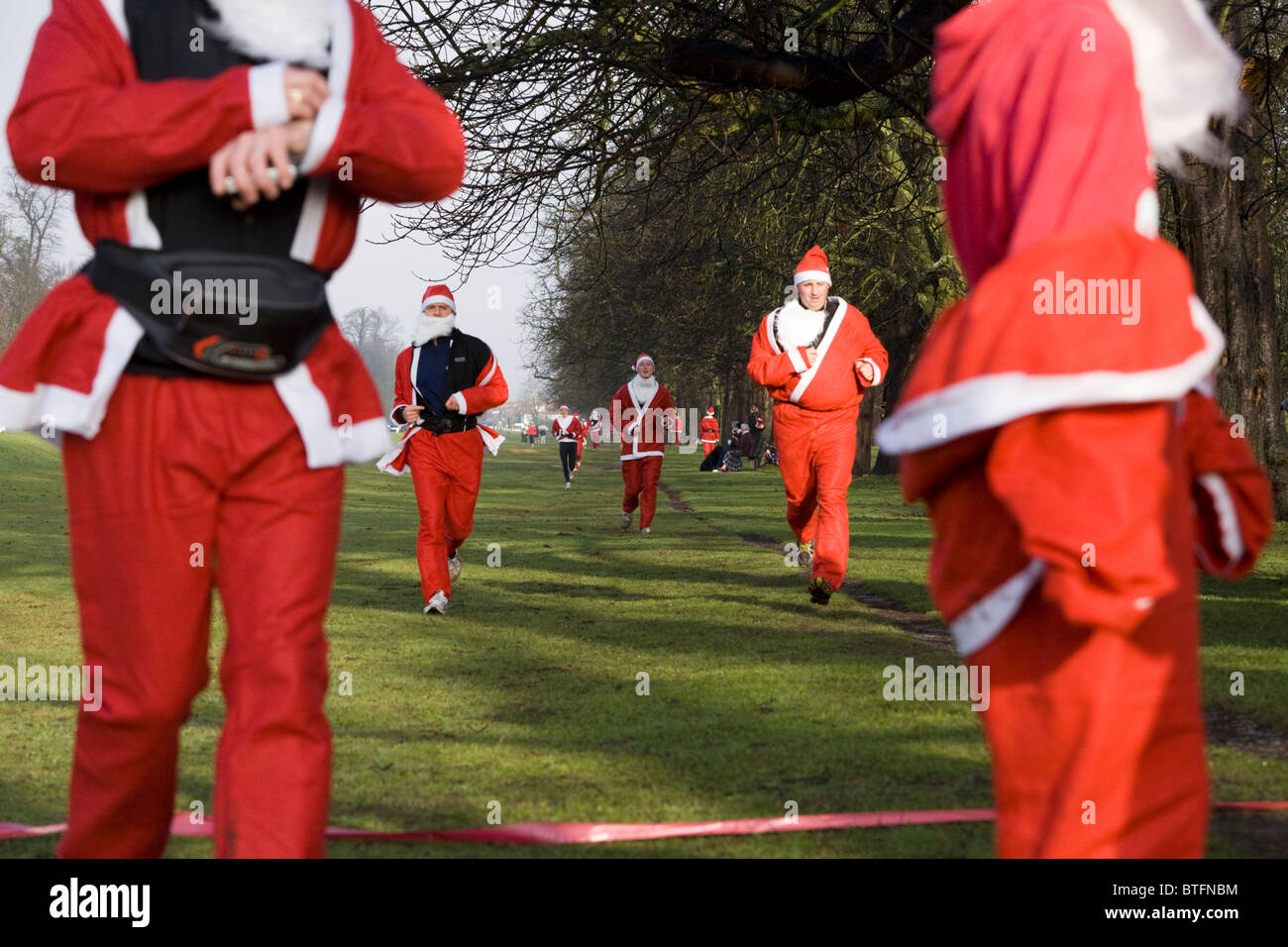 Male / man runner / runners / running / runs across finish line (as ...