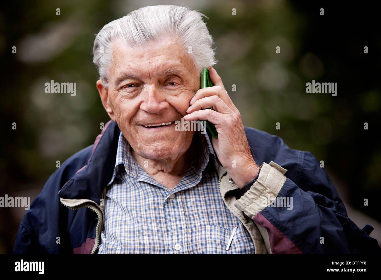 A portrait of a senior using a cell phone outdoors Stock Photo - Alamy