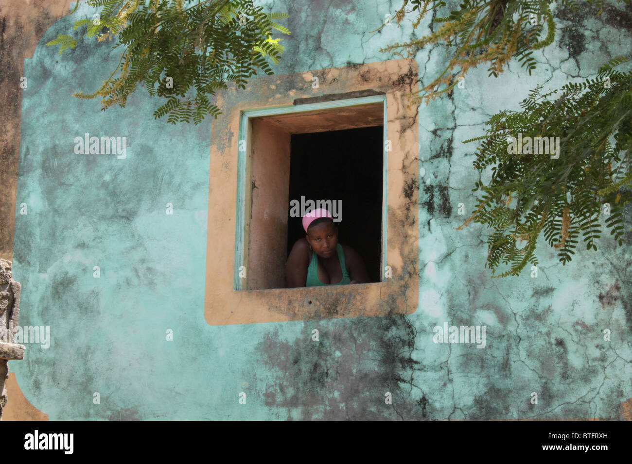 Cape Verdian Girl looking through a window Stock Photo - Alamy