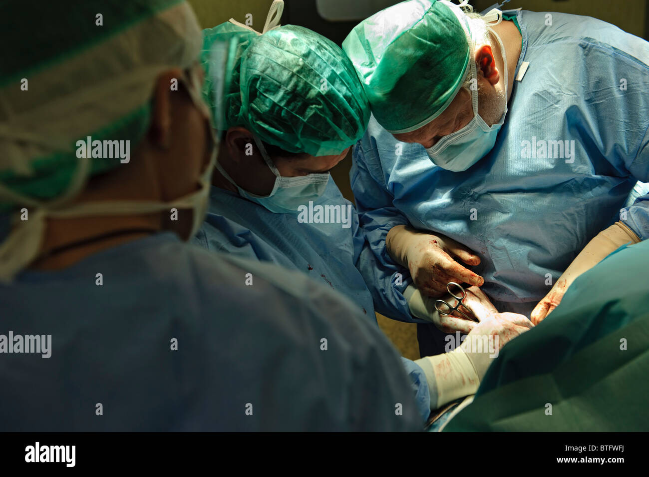 Doctors performing surgery in operating room Stock Photo - Alamy