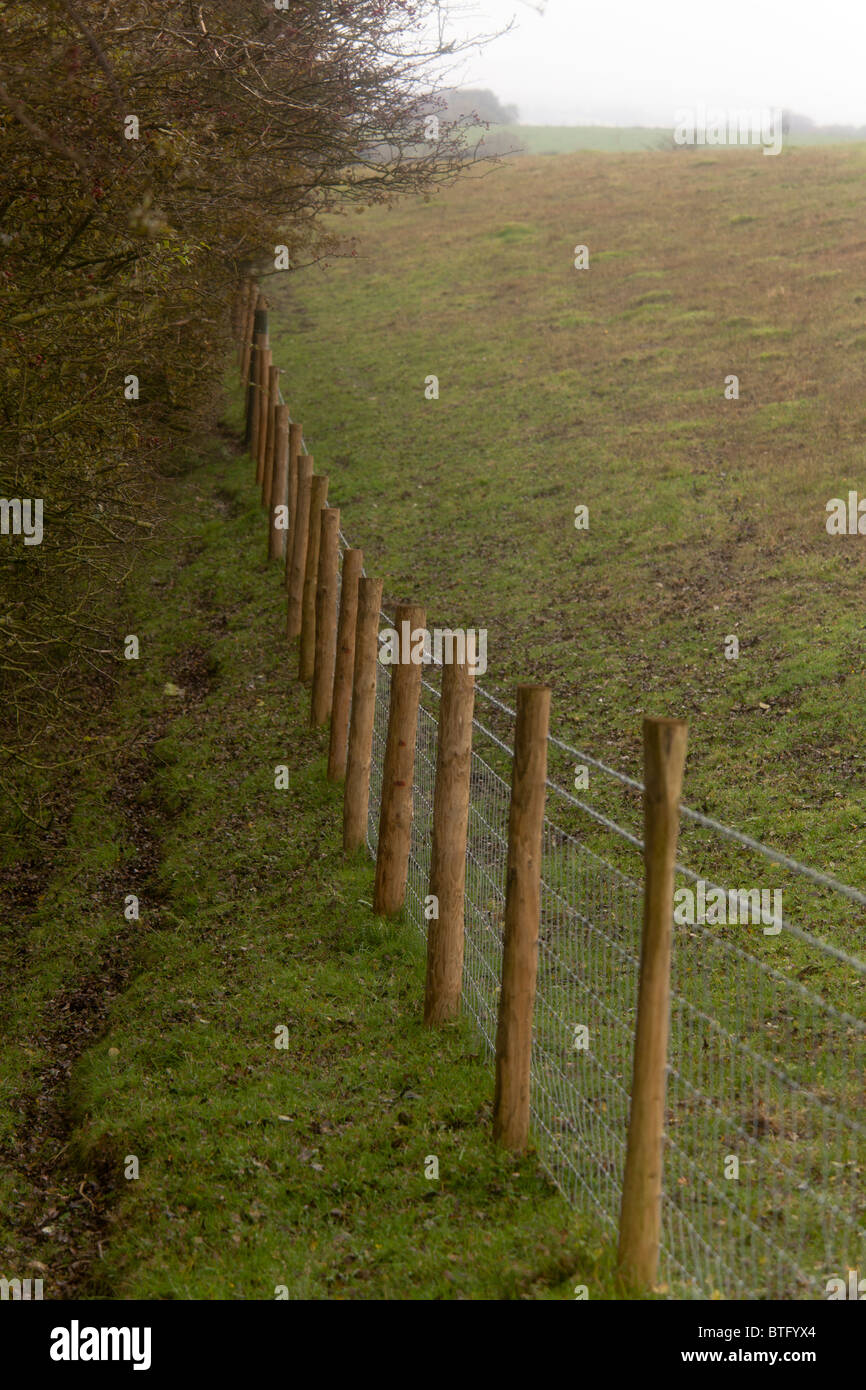 wire fencing and post in countryside with mist / low cloud rolling in ...