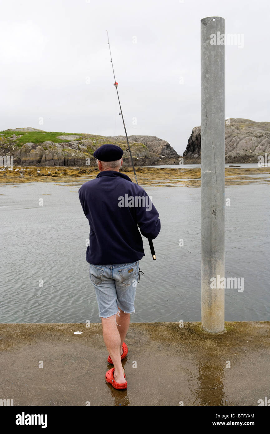 Irish man is fishing by A fishing rod by the coast Stock Photo - Alamy
