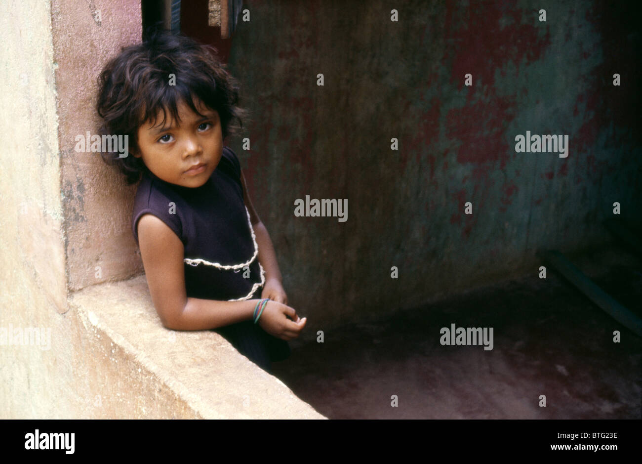 Mexico, Tabasco, Villahermosa, A young girl watching at her window ...