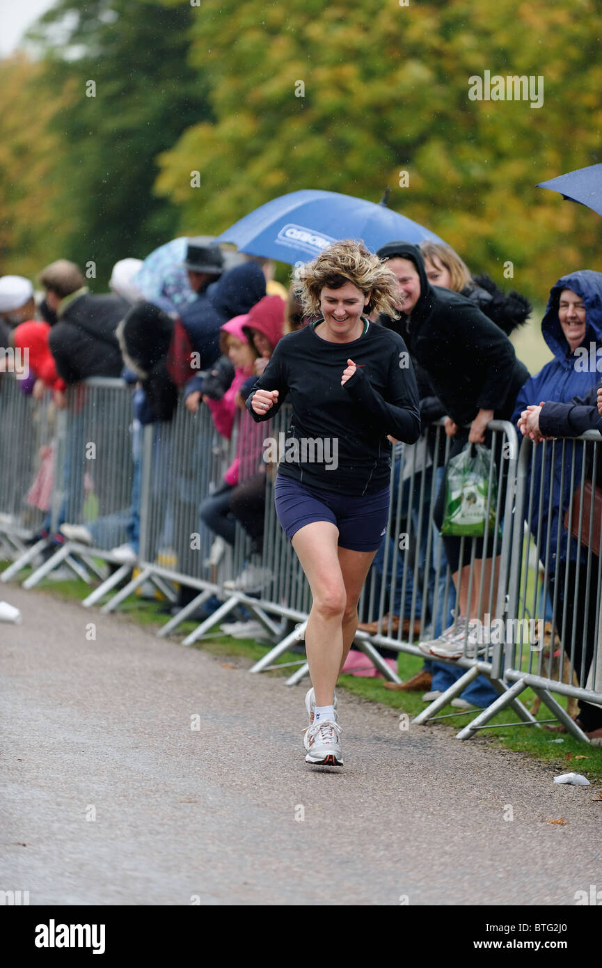 woman running in the rain at the Windsor Great Park half marathon in ...