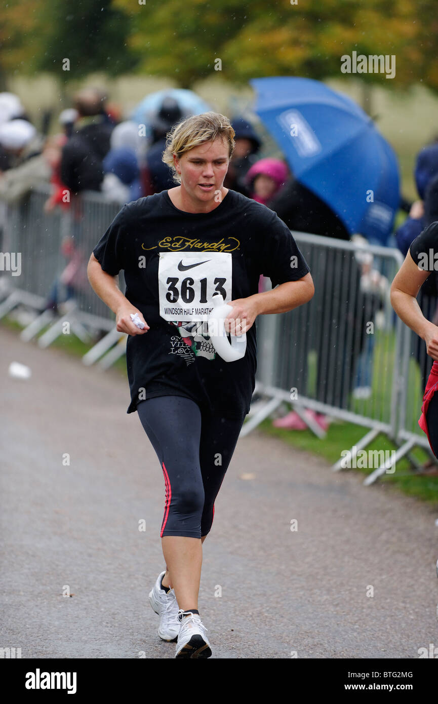 Woman running in the rain at the Windsor Great Park half marathon in ...