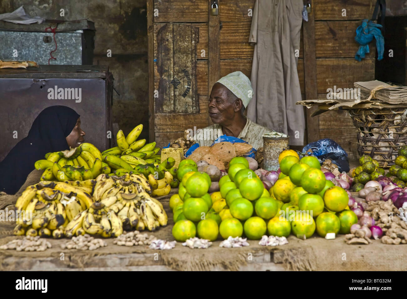 a man and a woman selling fruit at the stone town market in zanzibar ...