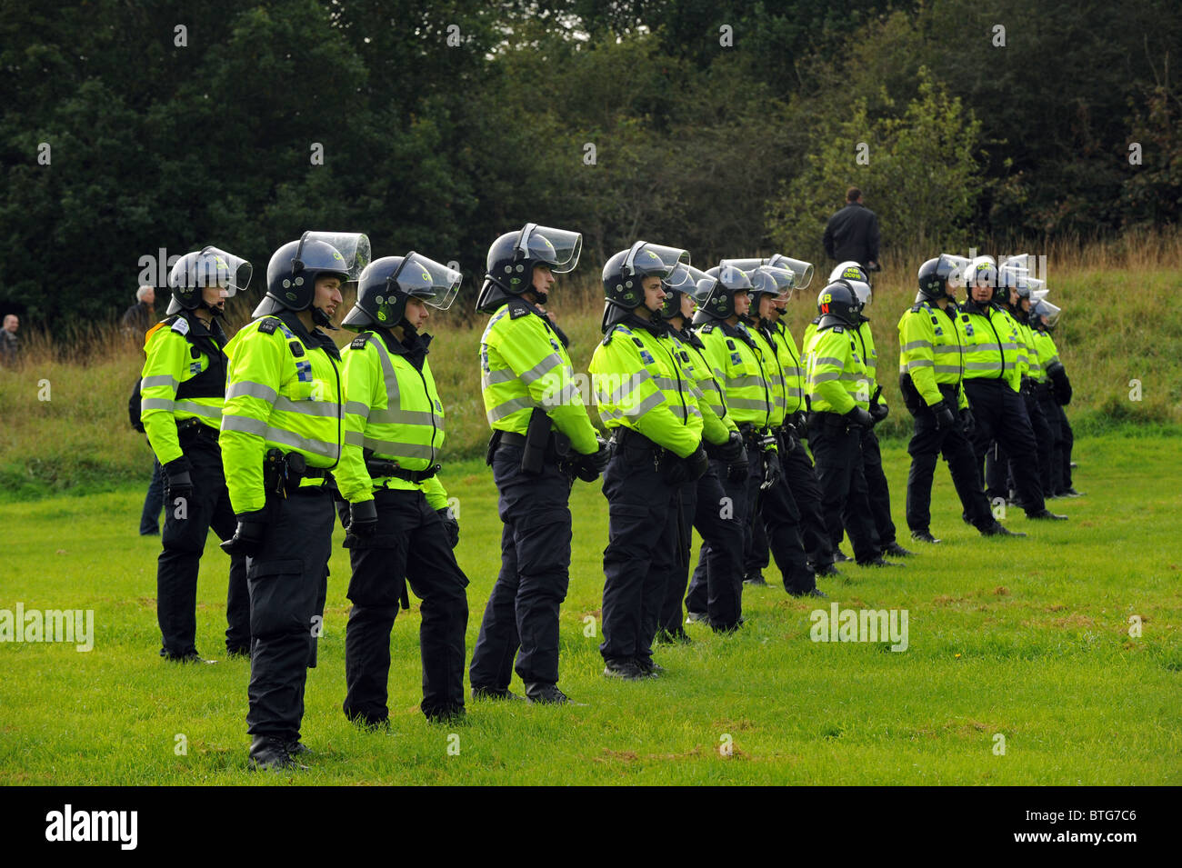 Police officers in riot gear line up to deal with protesters during a ...