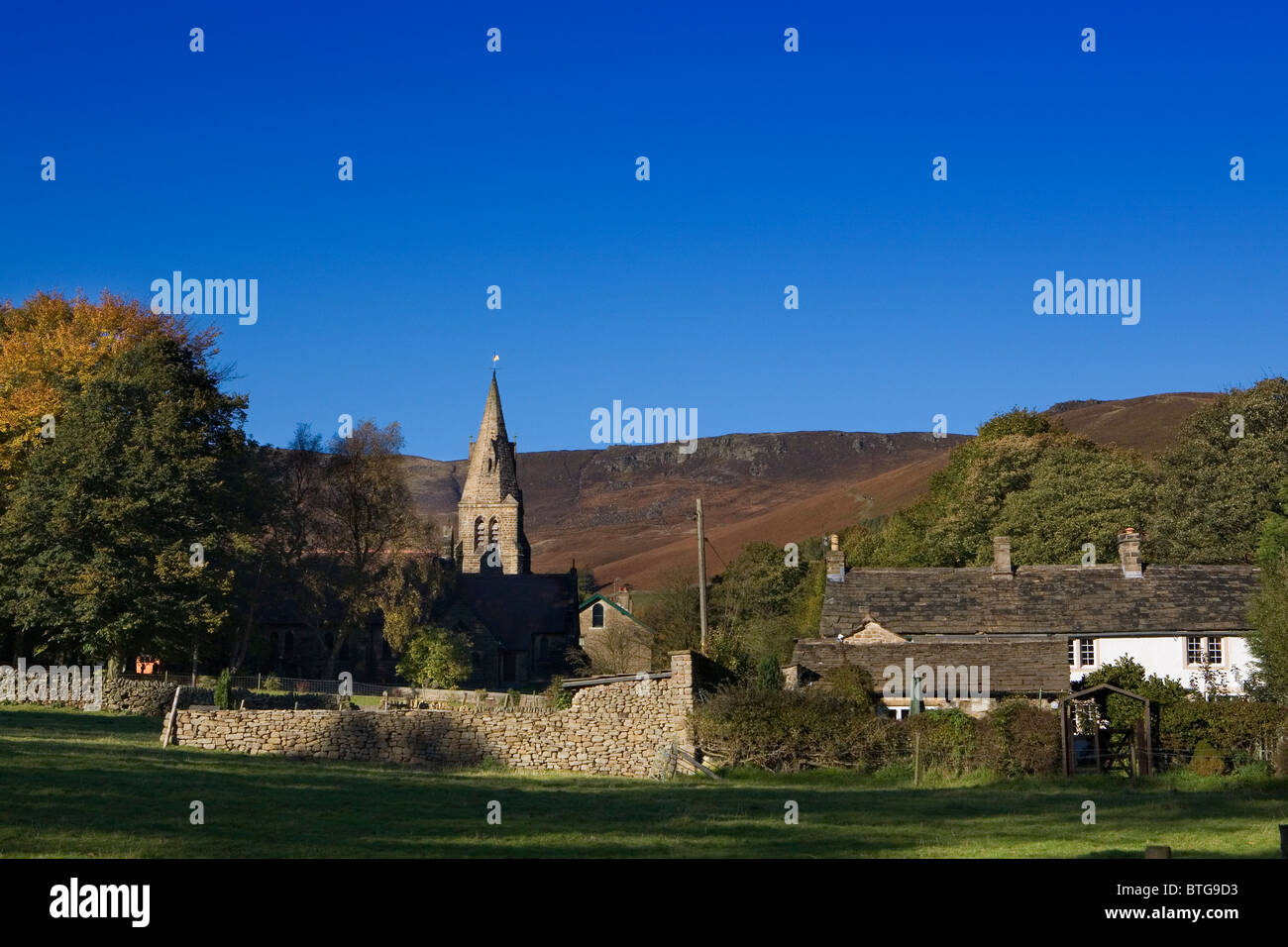 Edale church and village in autumn with Kinder Scout in the background ...