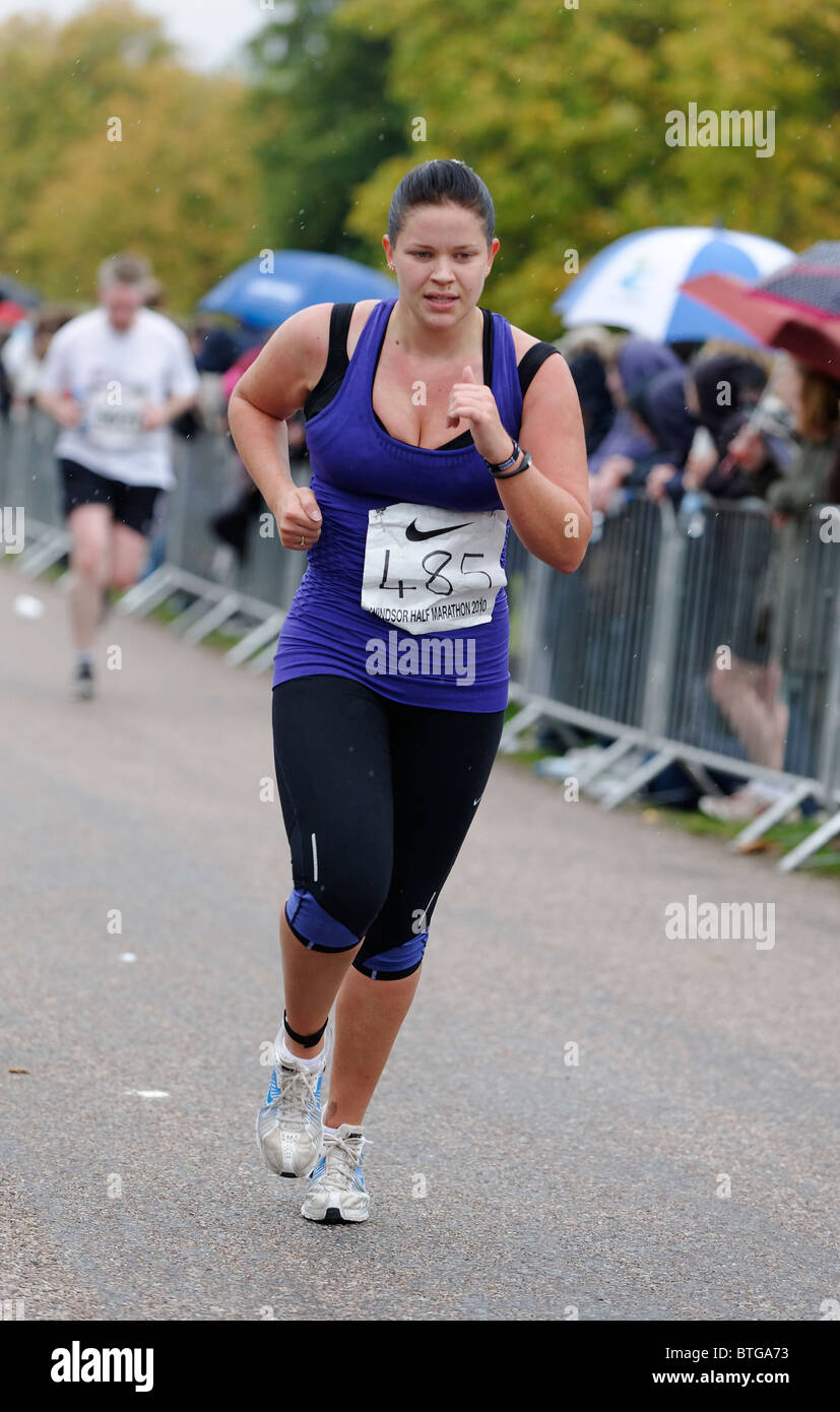 Woman running in the rain at the Windsor Great Park half marathon in ...