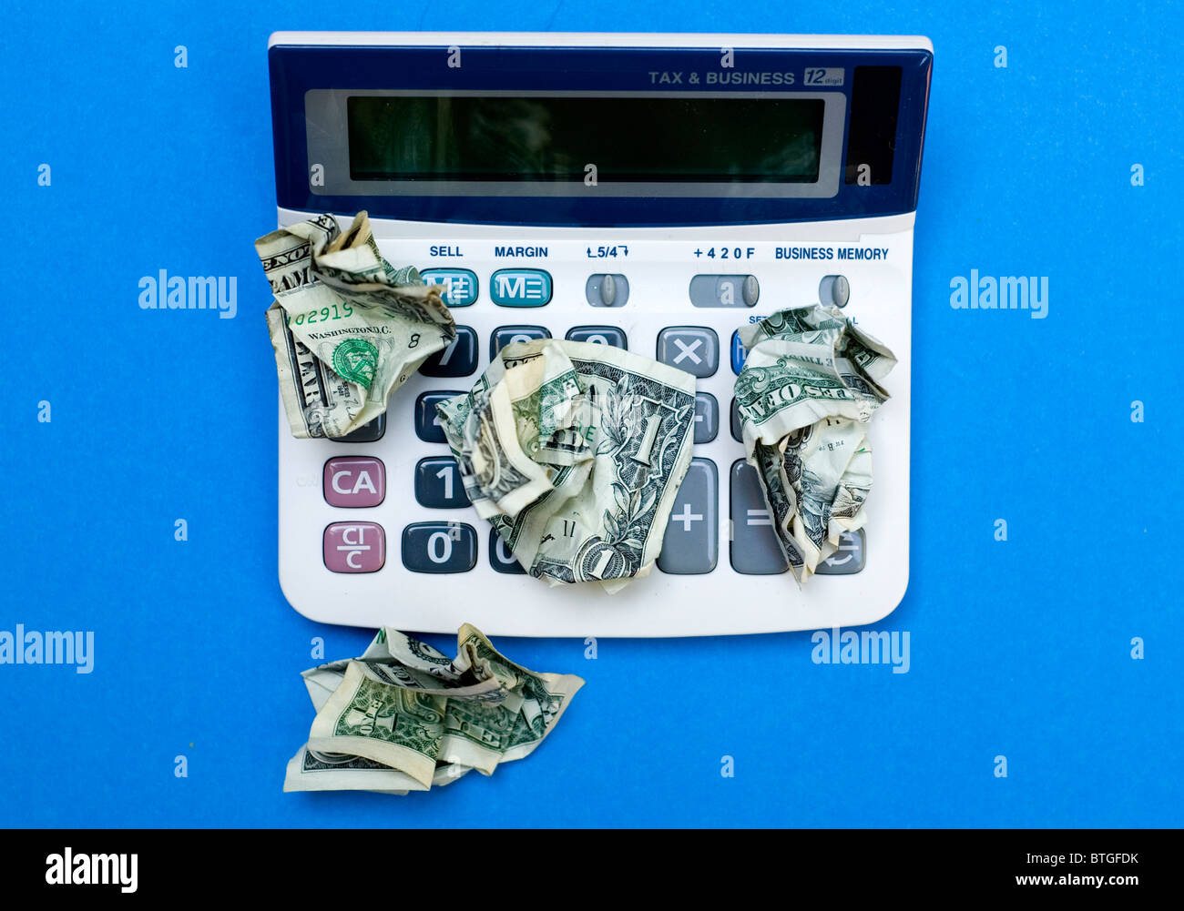 Scrunched up American dollar bills on top of calculator Stock Photo - Alamy
