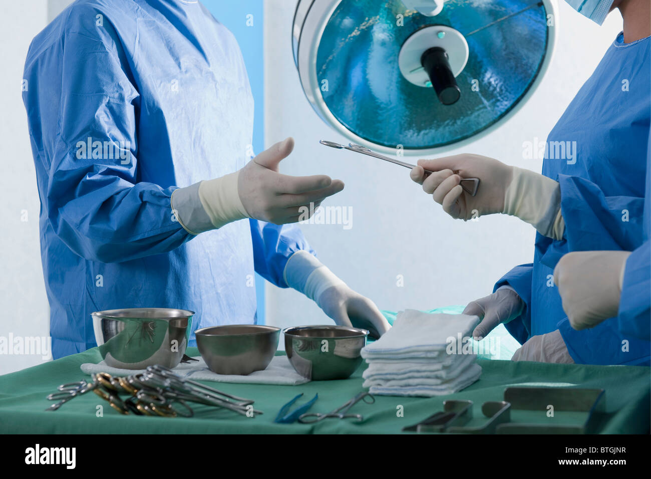 Nurse handing forceps to surgeon in operating room Stock Photo - Alamy