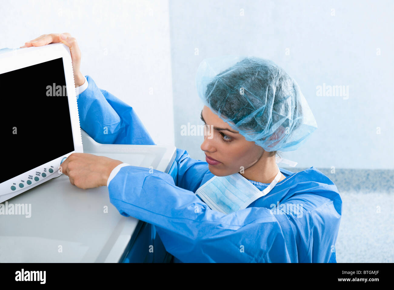 Surgeon adjusting monitor in operating room Stock Photo - Alamy