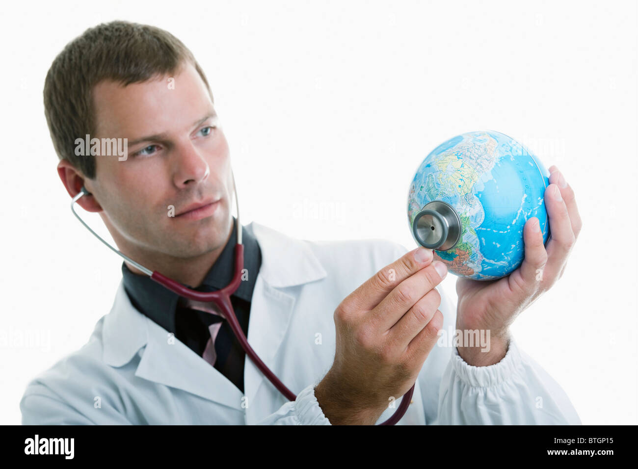 Doctor holding stethoscope to globe Stock Photo - Alamy