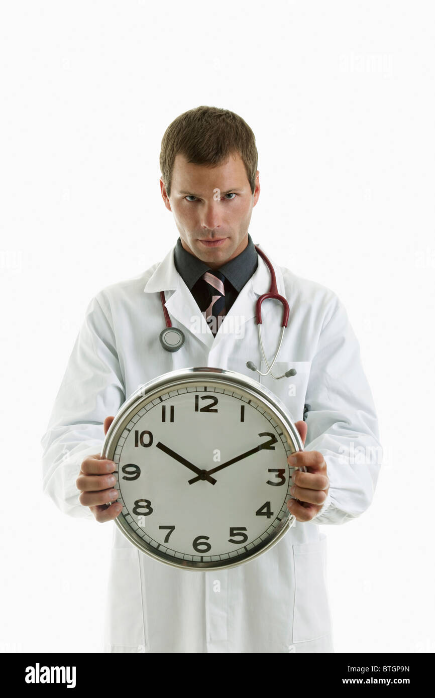 Doctor holding clock Stock Photo - Alamy