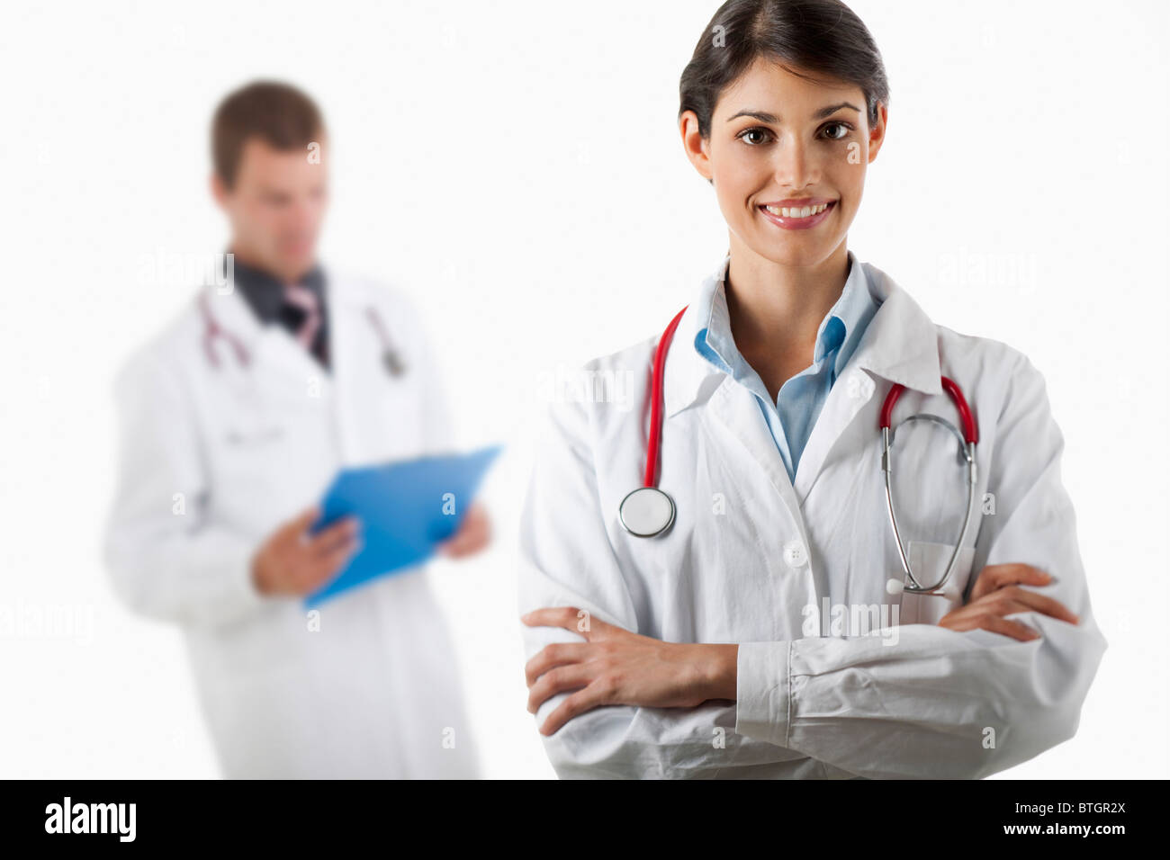 Doctor with arms folded and doctor reading medical chart Stock Photo ...