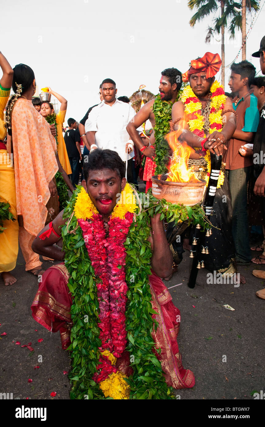 Hindu pilgrim in trance carrying a pot of fire during Thaipusam ...