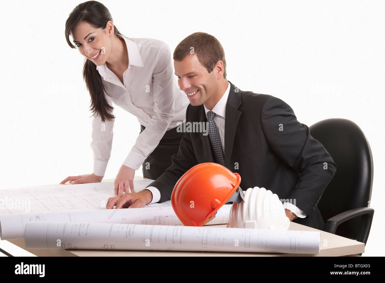 Man and woman looking over plans at desk Stock Photo - Alamy