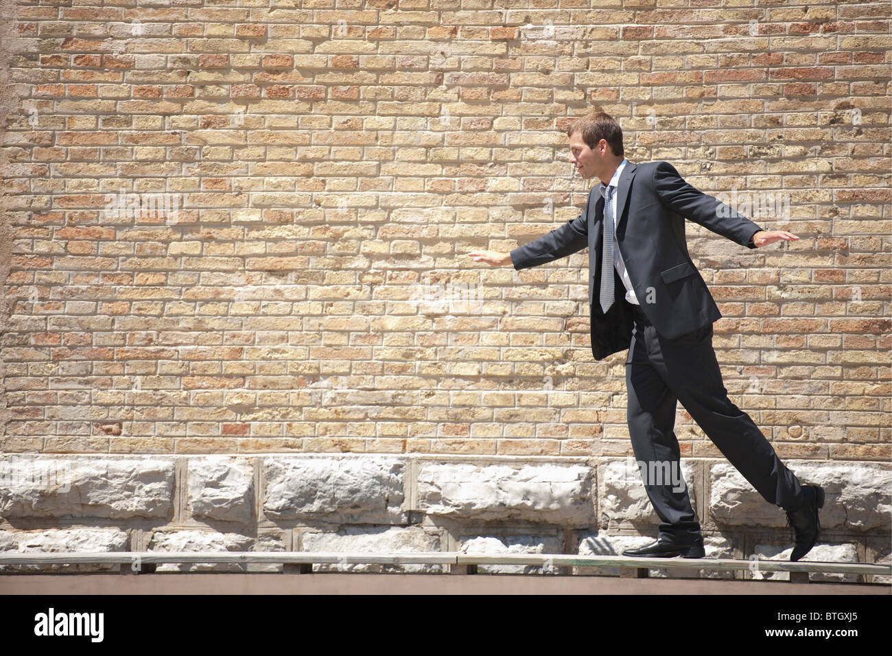 Man in suit walking on ramp by wall Stock Photo - Alamy