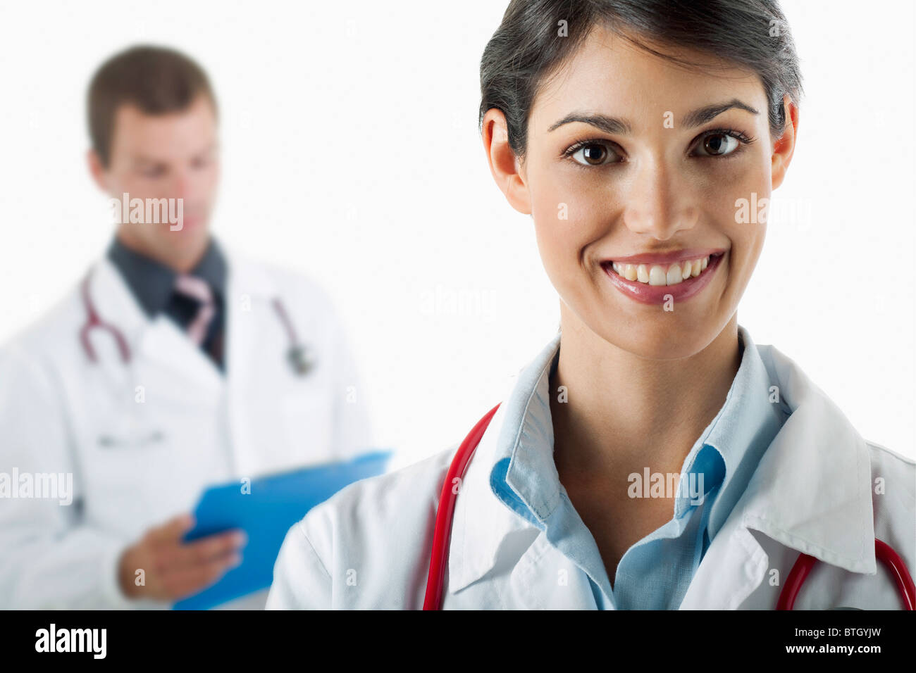 Doctor smiling and doctor reading medical chart Stock Photo - Alamy