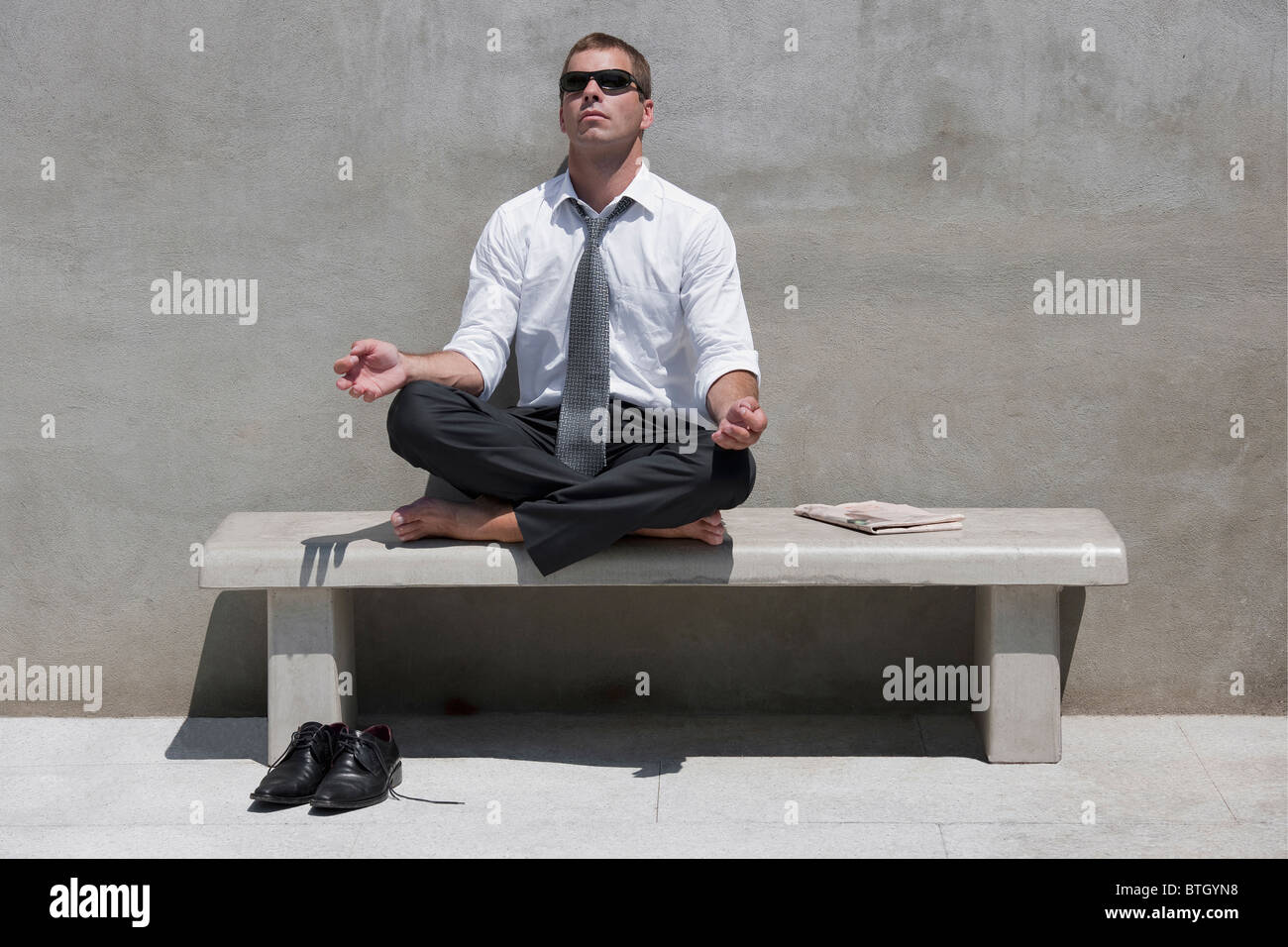 Barefoot businessman sitting on bench enjoying the sun Stock Photo - Alamy