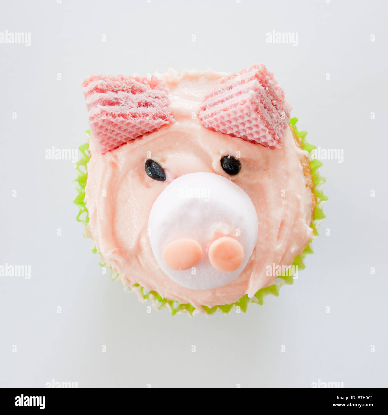 A pink pig iced homemade bun for a childs birthday party Stock Photo ...
