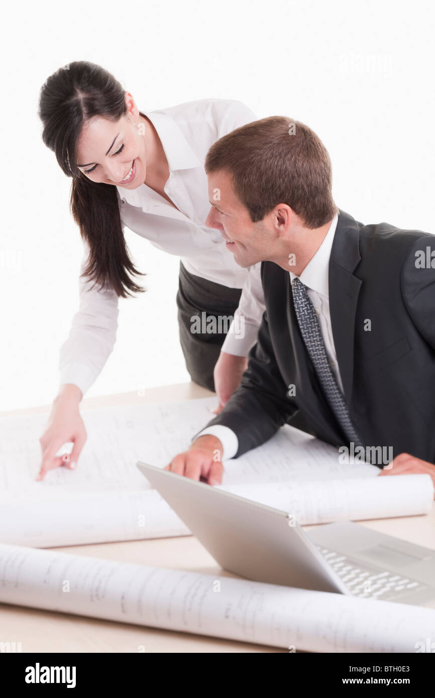 Man and woman looking over plans at desk Stock Photo - Alamy