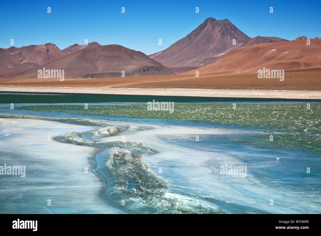 view on frozen lagoon Quepiaco and volcano Acamarachi in Atacama desert ...