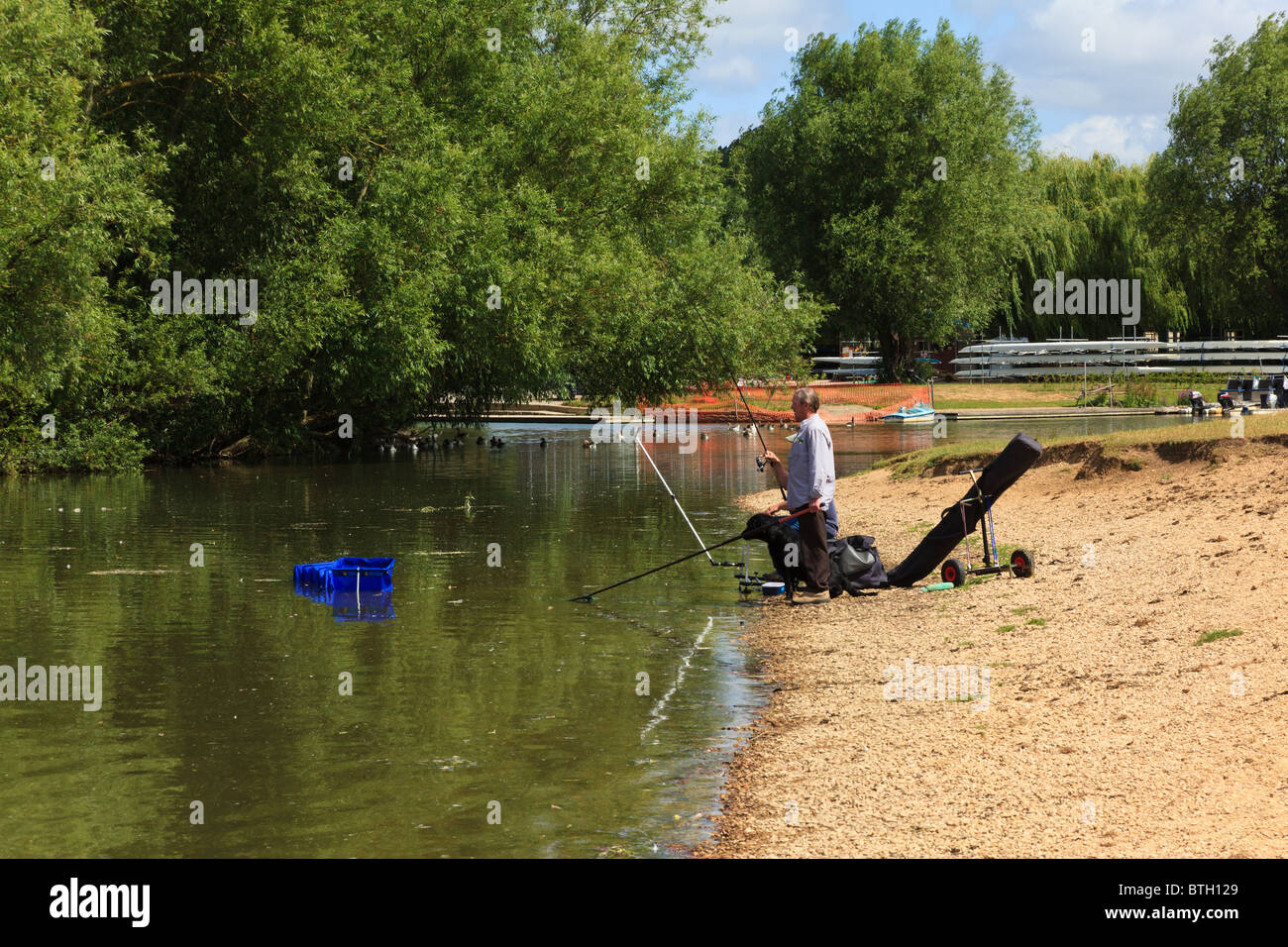 Angler and Dog Walker talk on the banks of the River Thames at ...