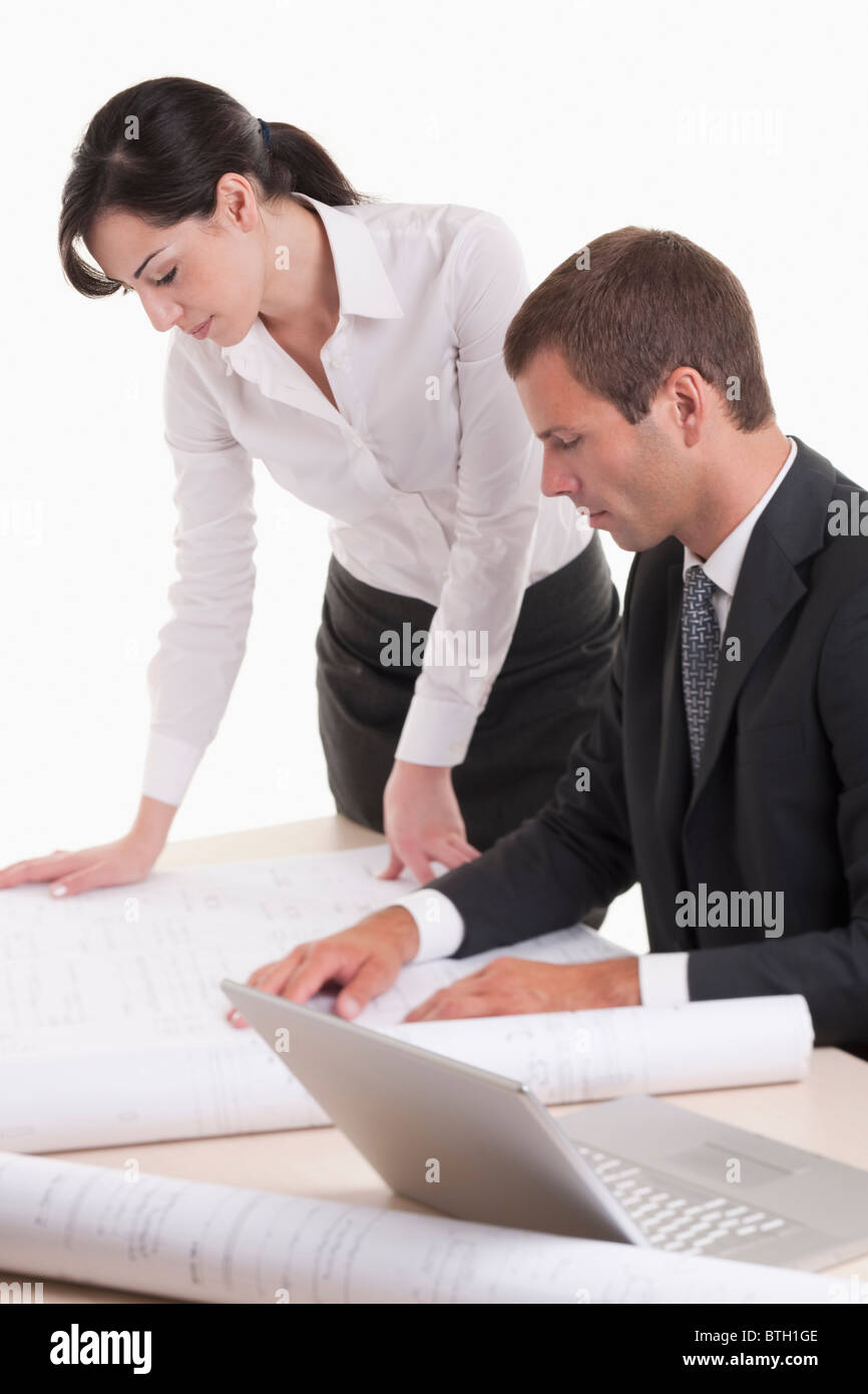 Man and woman looking over plans at desk Stock Photo - Alamy