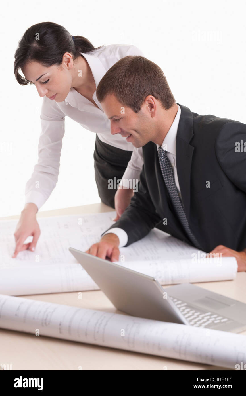 Man and woman looking over plans at desk Stock Photo - Alamy