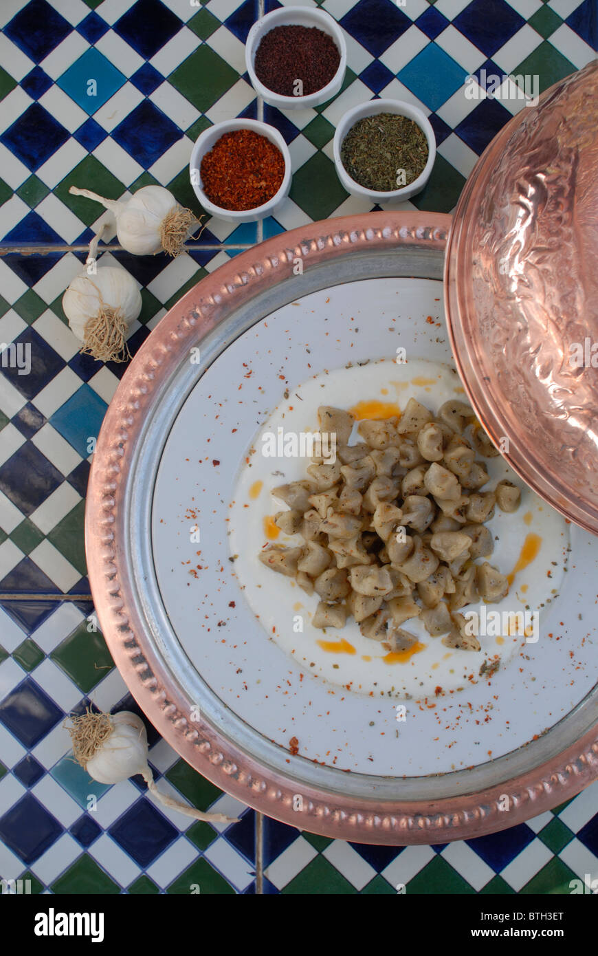 traditional Turkish food mantı served and prepared with yogurt and ...