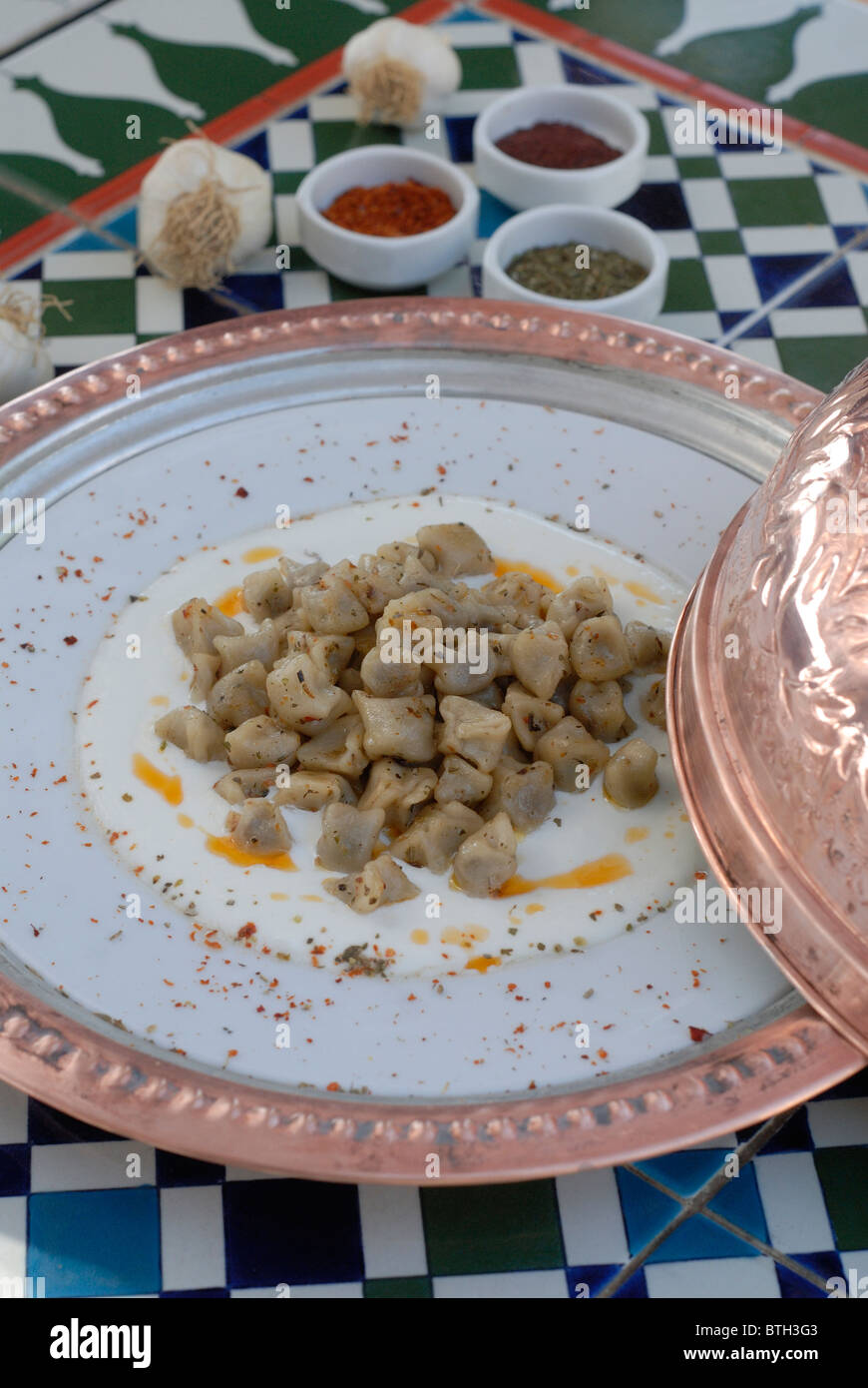 traditional Turkish food mantı served and prepared with yogurt and ...