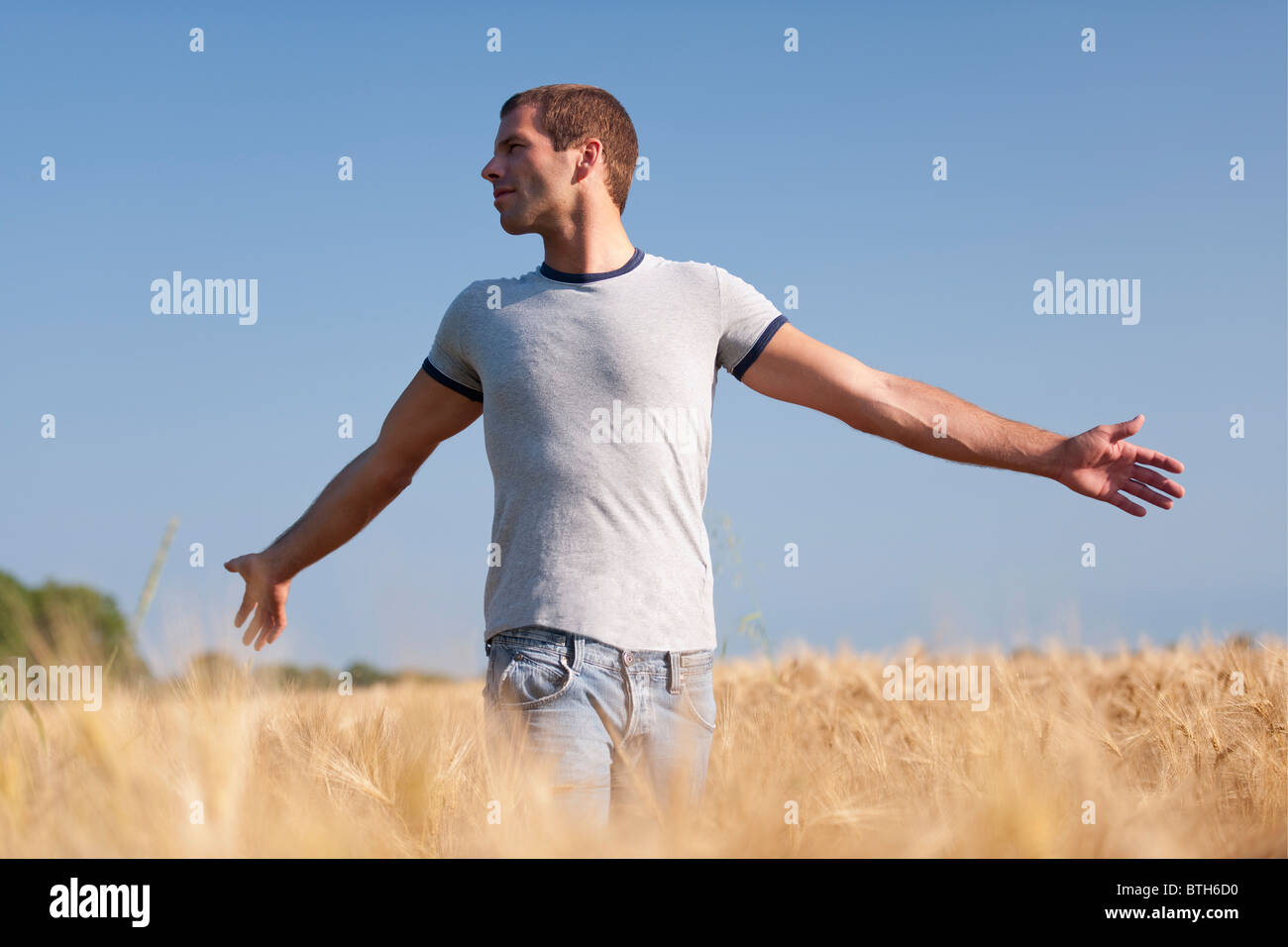 Man with arms stretched out in wheat field Stock Photo - Alamy