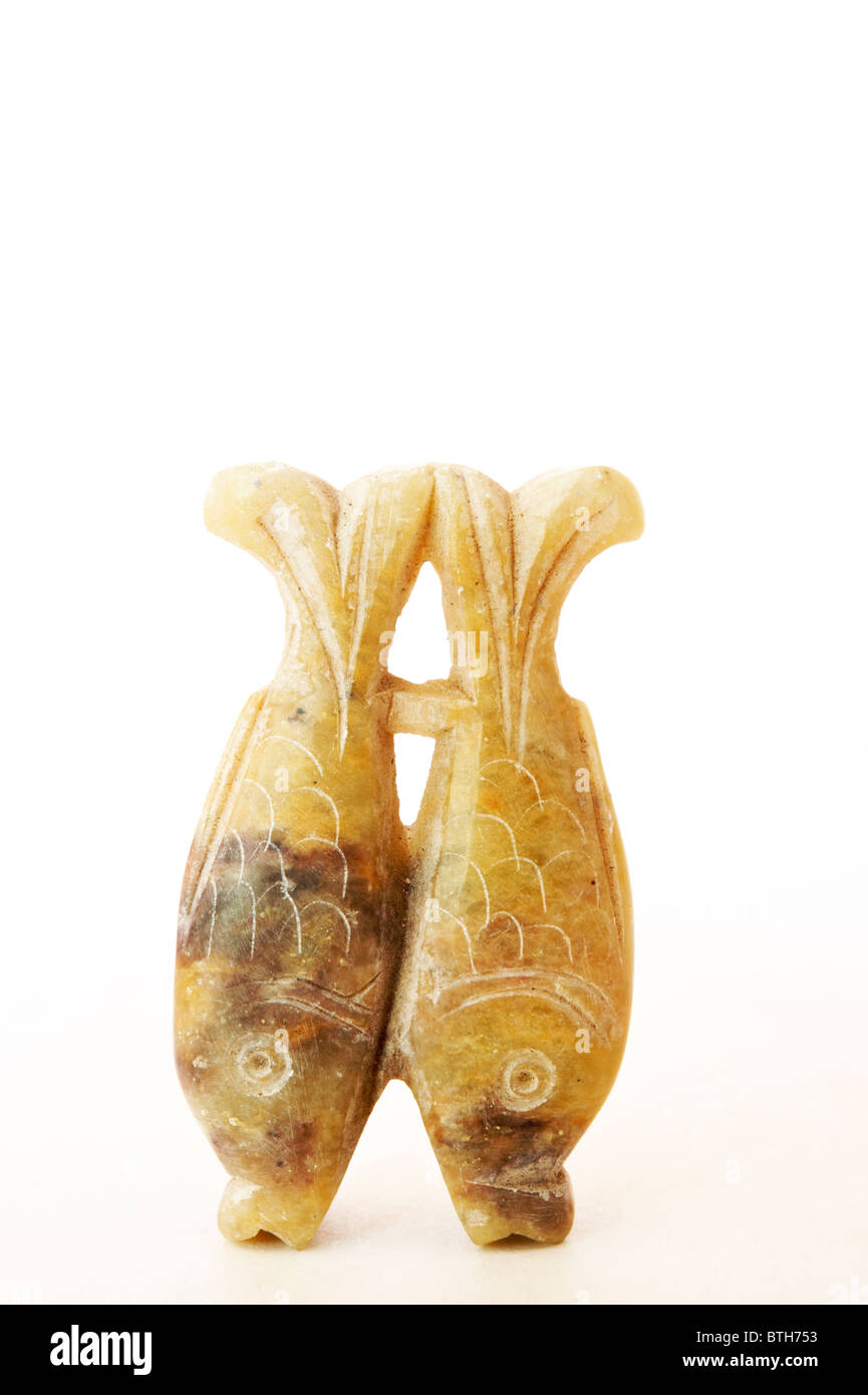 A small stone whistle in the shape of a double fish, isolated on a ...